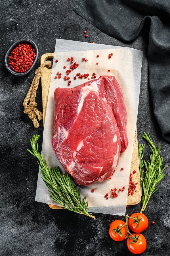 Raw Round Beef Cut on a Cutting Board. Black Background. Top View Stock ...