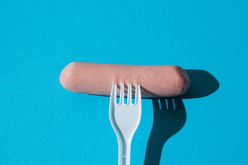 Raw Sausage on a Blue Background with a Plastic Fork Stock Photo ...