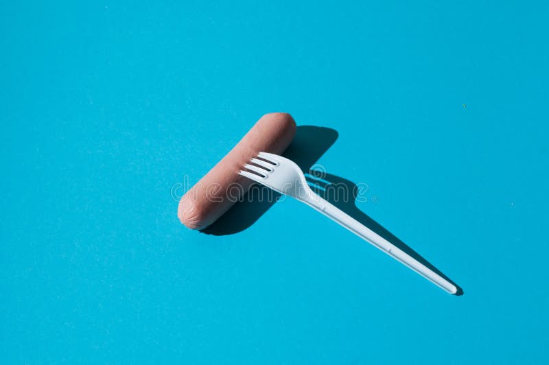 Raw Sausage on a Blue Background with a Plastic Fork Stock Photo ...