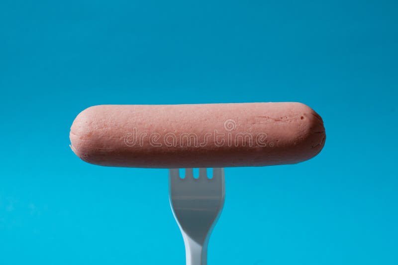 Raw Sausage On A Blue Background With A Plastic Fork Stock Photo ...