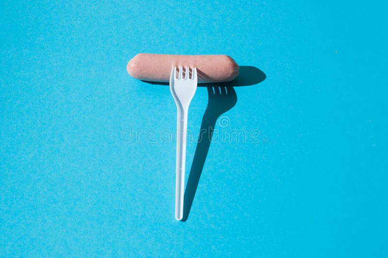 Raw Sausage on a Blue Background with a Plastic Fork Stock Photo ...