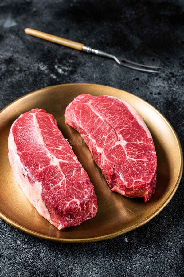 Raw Shoulder Top Blade Beef Meat Steaks on a Plate. Black Background ...