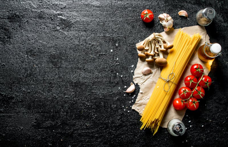 Raw Spaghetti on Paper with Mushrooms, Spices and Tomatoes on a Branch ...