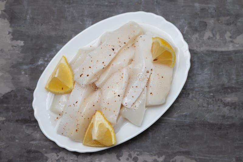 Raw Squid with Pepper and Fresh Lemon on White Dish Stock Image - Image ...