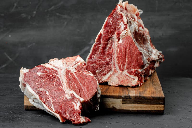 Raw T-bone Steak Cooking on Stone Dark Table. Stock Photo - Image of ...