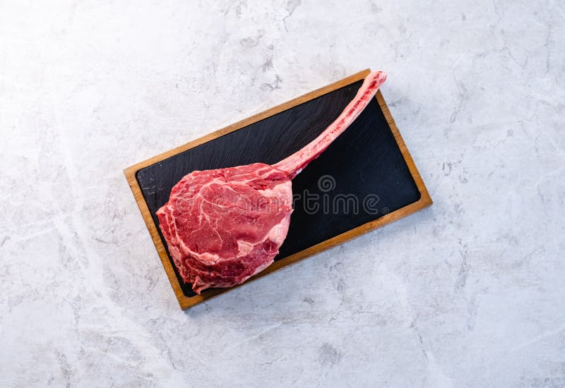 Raw tomahawk steak on tray stock photo. Image of beef - 277498352