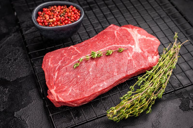Raw Top Sirloin Beef Steak with Thyme on a Rack. Black Background Stock ...