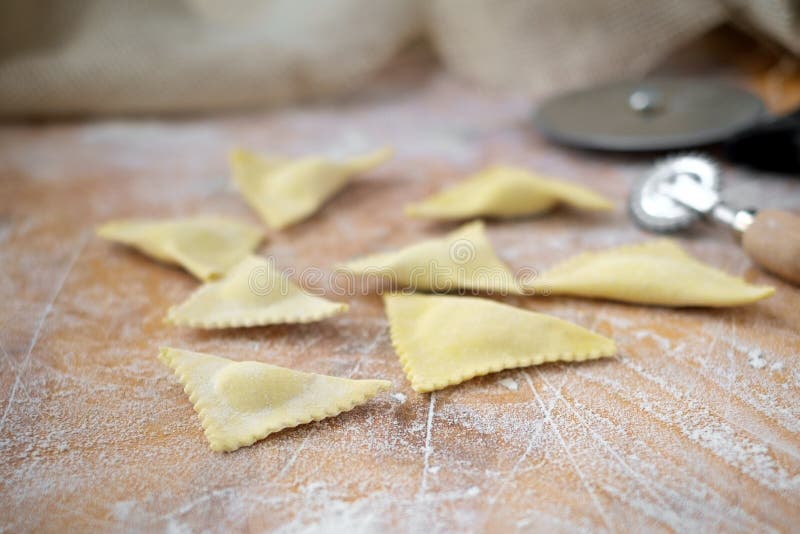 Raw Triangular Ravioli on a Wooden Kitchen Table in Flour Stock Image ...