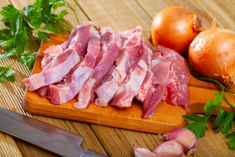 Uncooked Raw Turkey Necks Meat on a Butcher Wooden Board with Cleaver ...