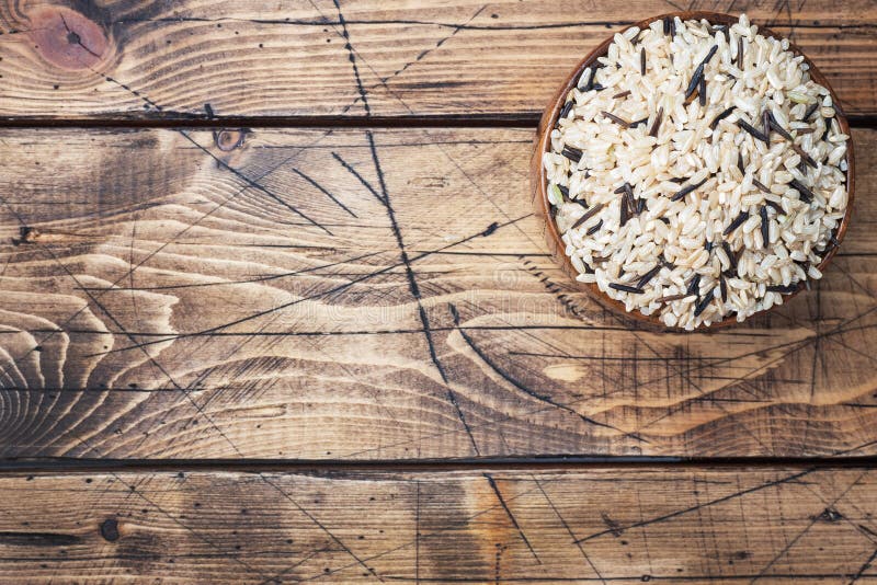 Raw Wild Rice in a Wooden Bowl. Raw Rice Grits on a Wooden Background ...