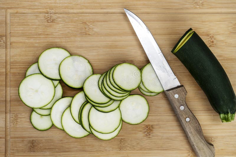 Raw Zucchini with a Sharp Knife and Stack Many Thin Slices on a Bamboo ...
