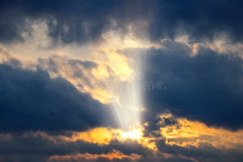 A Ray of Sunlight Breaks through the Dark Storm Clouds during Sunset. a ...