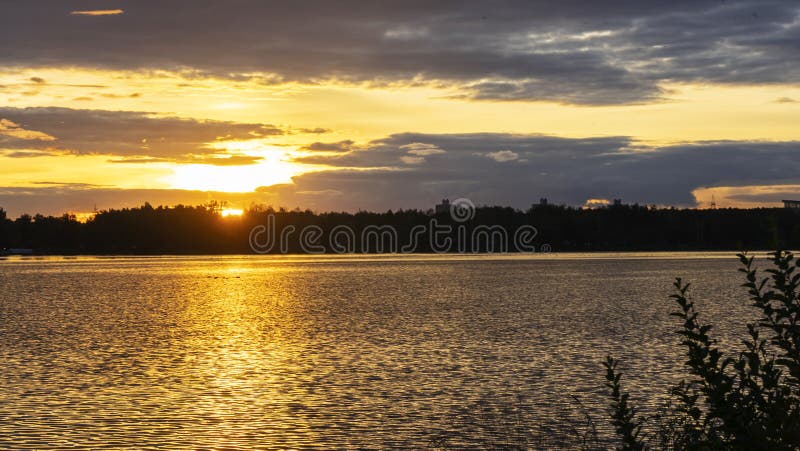 The Rays of the Dawn Sun on the Lake. Reflection of Sunset Clouds in ...