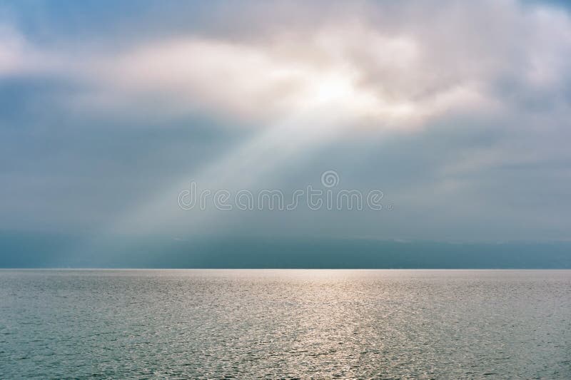 Rays of Light Falling through Clouds on Calm Water Stock Image - Image ...
