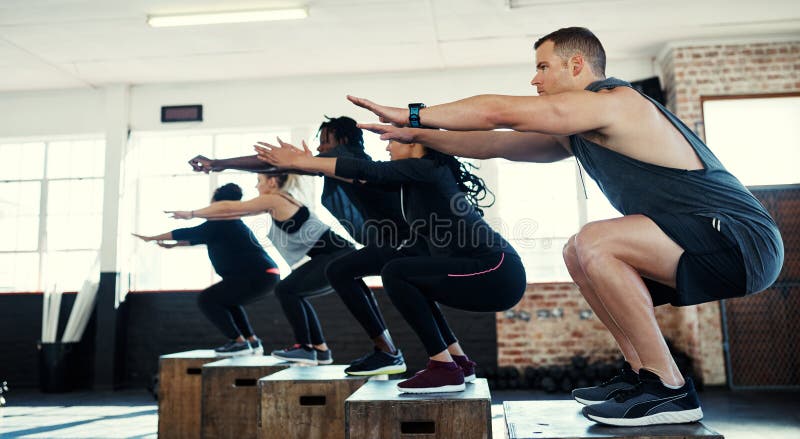 Reach Out. a Focused Group of Young People Doing Lunges on Crates As ...