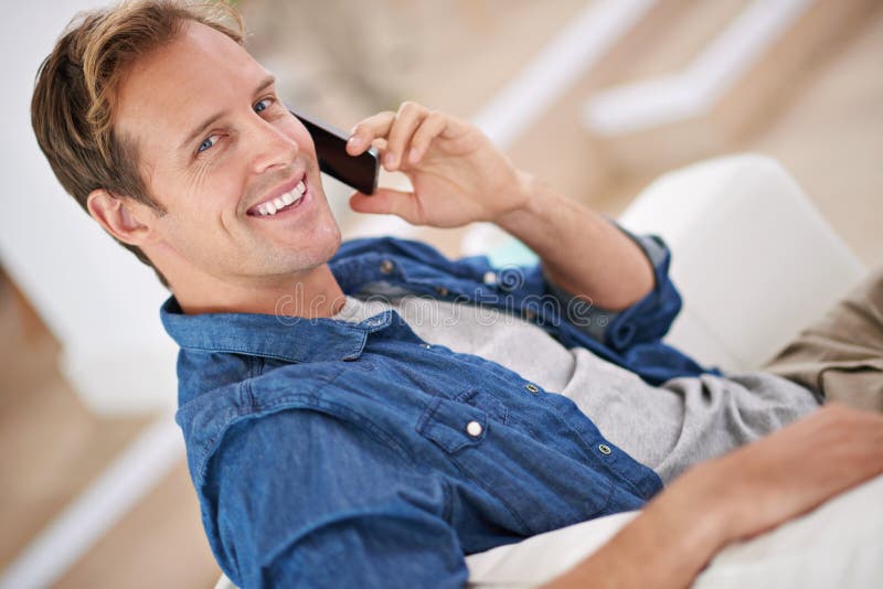 Reaching Out To the World. a Handsome Man Talking on the Phone at Home ...