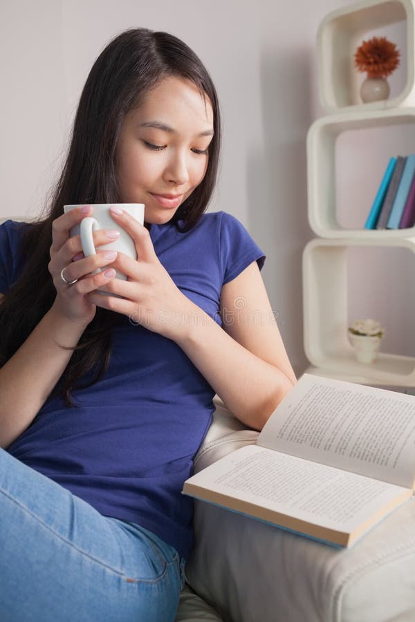 Reading Asian Woman Sitting on the Couch Holding Mug Stock Photo ...