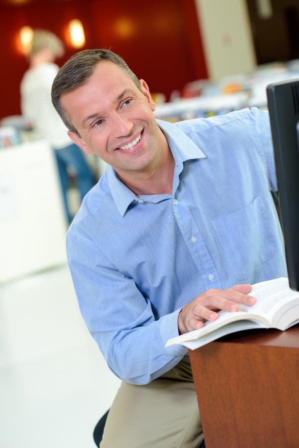 Reading book at desk stock image. Image of electronics - 84632351