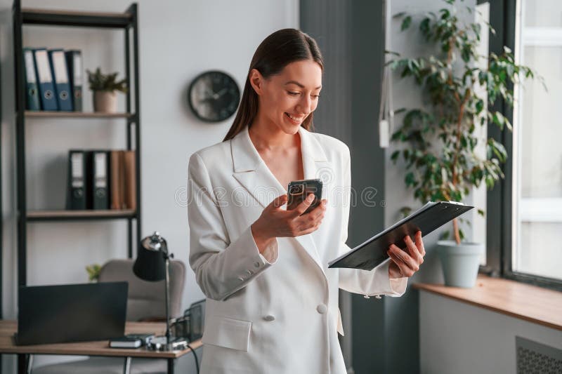 Reading Document in Notepad. Young Beautiful Woman in Formal Clothes is ...