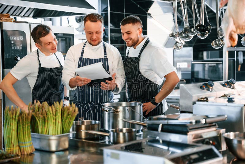 Reading the Documents. Kitchen Workers is Together Preparing the Food ...