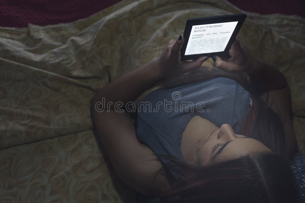Reading an ebook in bed stock image. Image of ereader - 45920257