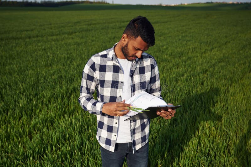 Standing and Holding Notepad. Handsome Indian Man is on the ...