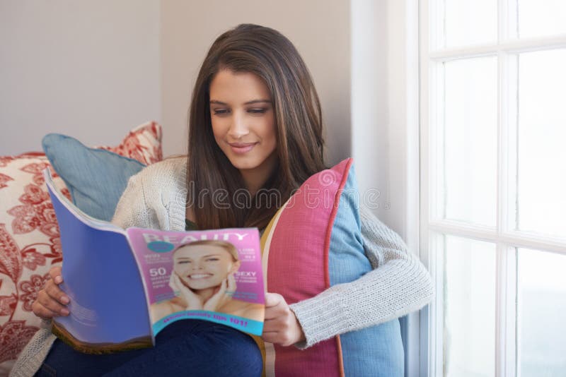Reading an Interesting Article. a Young Woman Reading a Book at Home ...