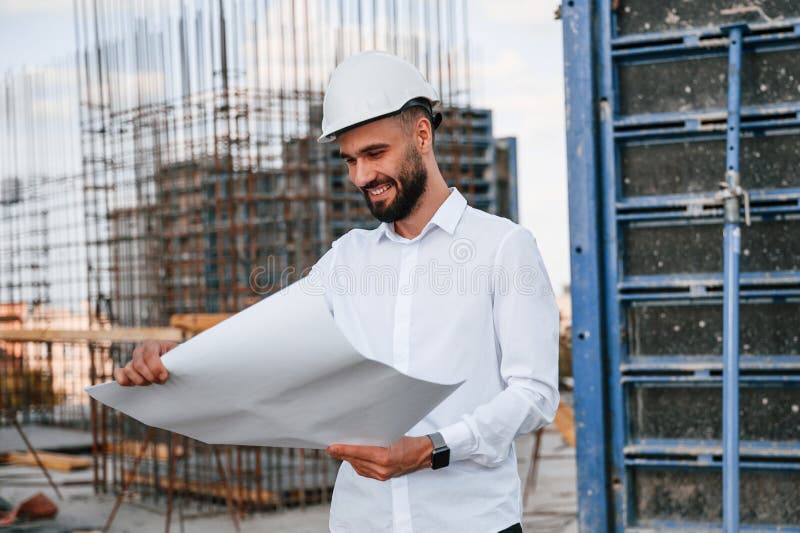 Reading the Plan. Man in Uniform is Working on the Construction Site ...