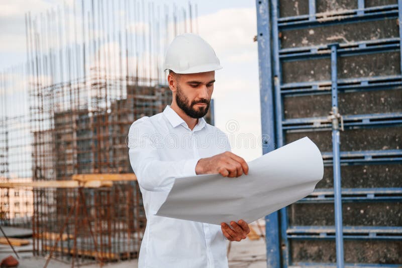 Reading the Plan. Man in Uniform is Working on the Construction Site ...