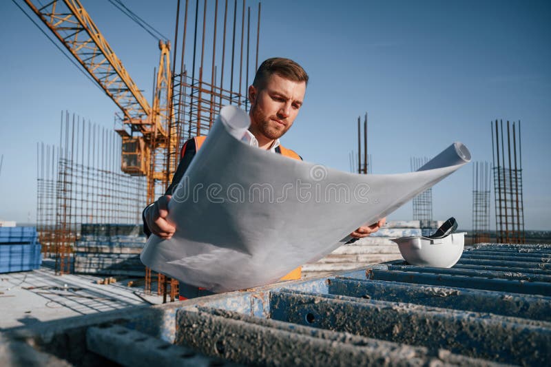 Reading the Plan. Man is Working on the Construction Site at Daytime ...