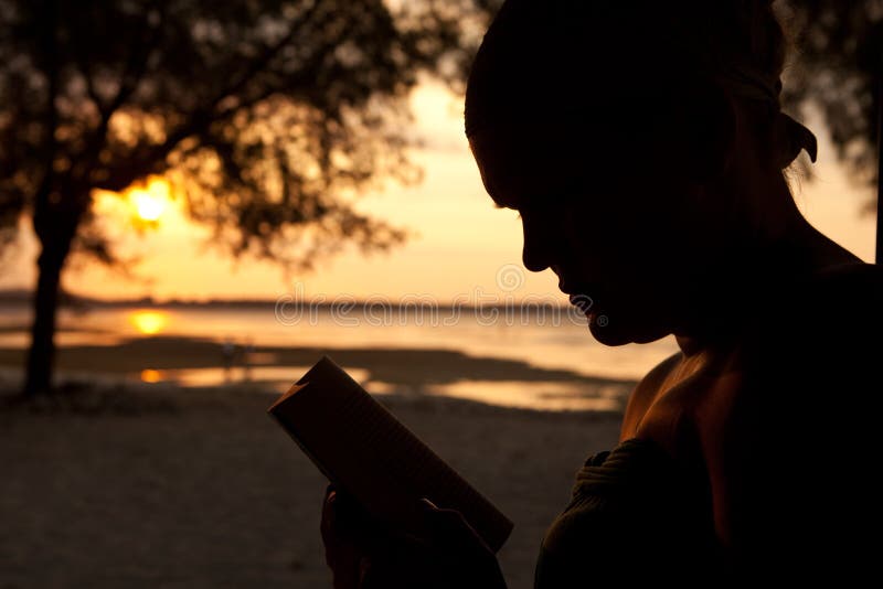 Reading in the sunset stock image. Image of seascape - 11147459