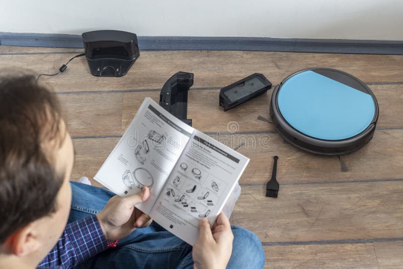Reading the User Guide for Robot Vacuum Cleaner Stock Photo - Image of ...