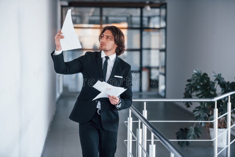 Reads Documents. Portrait of Handsome Young Businessman in Black Suit ...