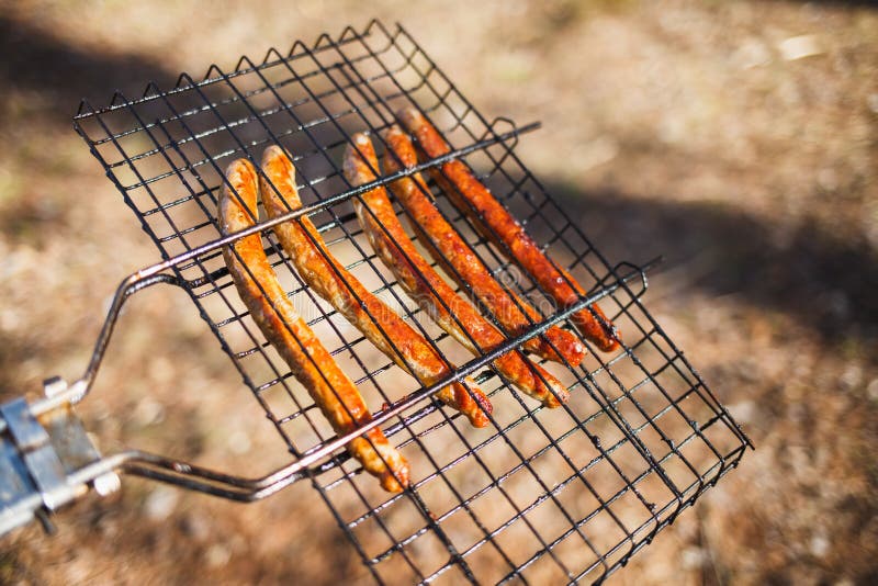 Ready-flavored Sausages on the Hand-held Grill in the Forest Stock ...
