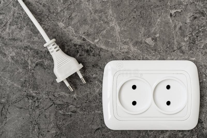 White Power Plug and Electric Socket on Stone Wall Stock Photo - Image ...