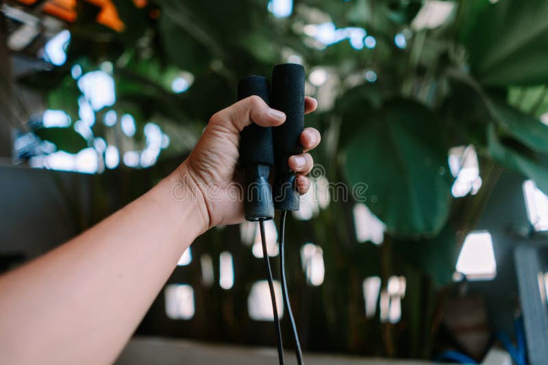 Ready for a Workout, Hand Gripping a Jump Rope with Natural Backdrop ...