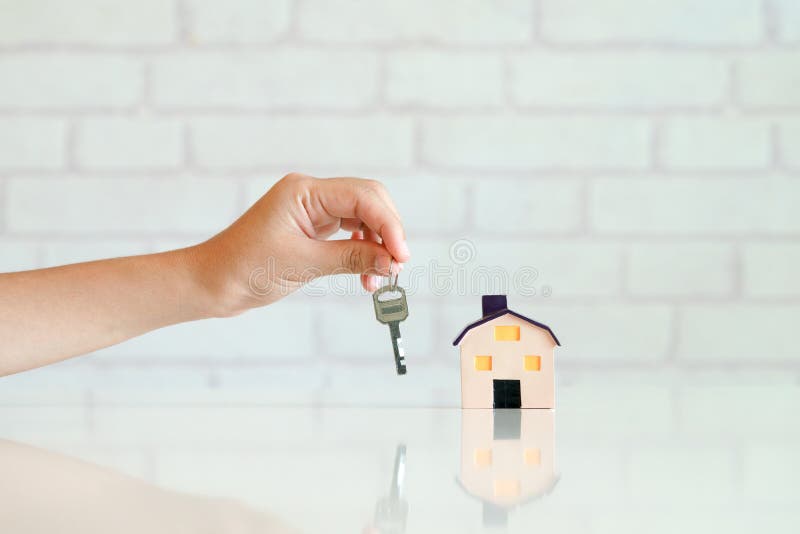 Real Estate Agent Hand Holding House Key and House Toy. Stock Photo ...