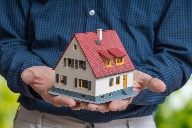 Real Estate Agent is Holding Small House in Hand Stock Photo - Image of ...