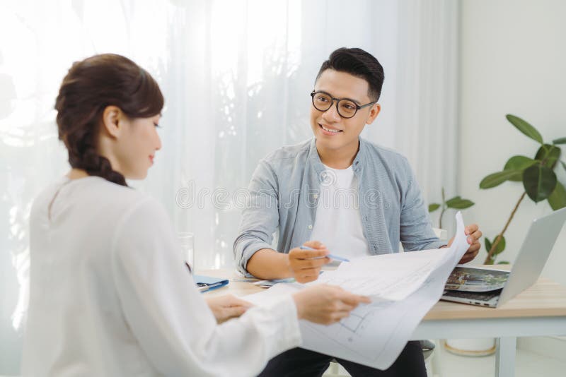 Real-estate Agent Showing House Plans for Client at Office Stock Photo ...
