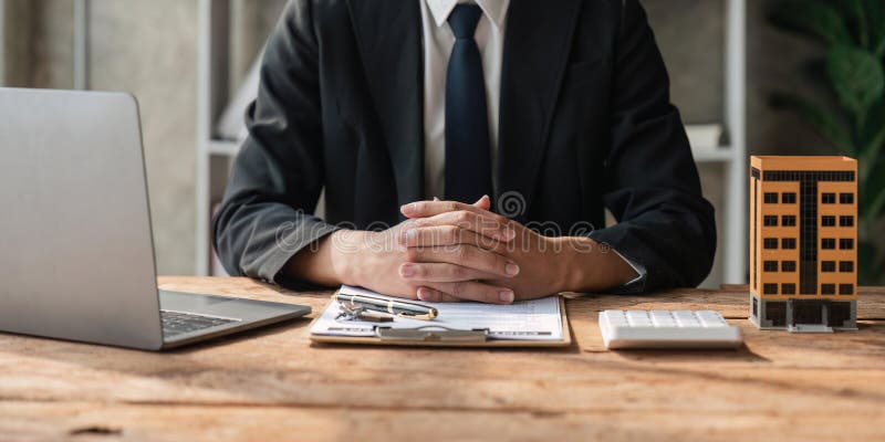 Real Estate Agent Working with Laptop at Table in Office Stock Photo ...