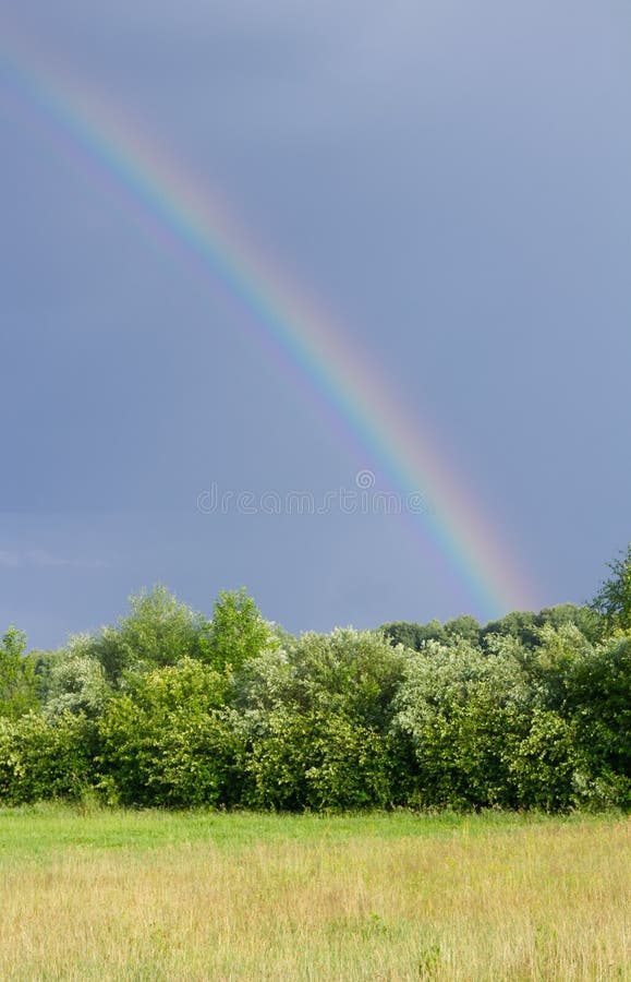 Real Rainbow in Dark Sky. Countryside Landscape with Fields and Trees ...