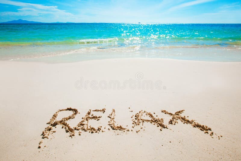 Realax writing on a beach stock image. Image of sign - 216397811
