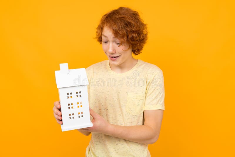 Realtor Guy Holds a House Model in His Hand on a Yellow Background with ...