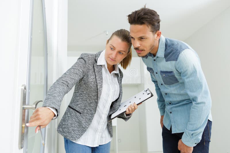 Realtor Pointing at Door Lock while Visiting Property with Client Stock ...