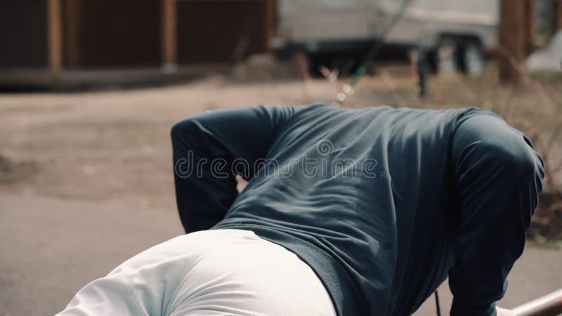 Rear Back View of Man Doing Push Ups Exercise on Bar on Winter Spring ...