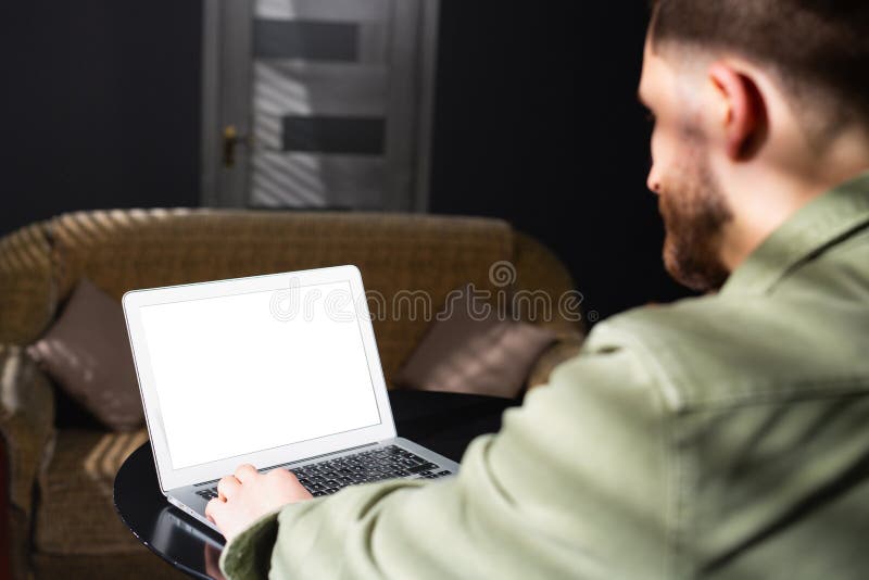 Rear Photo of a Man Working at a Table with a Laptop with a White ...