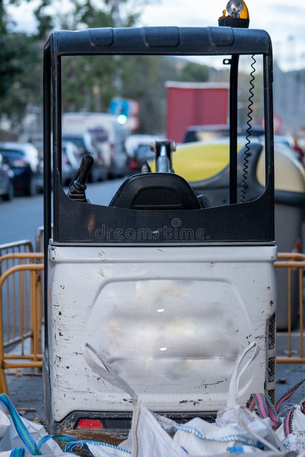 Rear of Small Backhoe in Front of Some Construction Container Bags in a ...