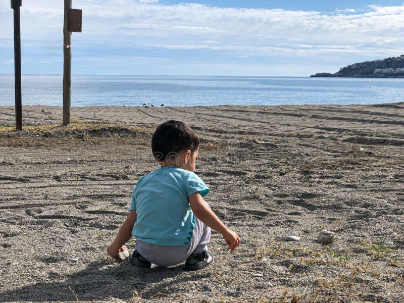 Rear View of a Boy Playing with Stones on the Beach Stock Image - Image ...