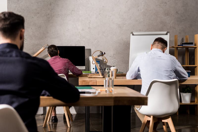Rear View of Businessmen Sitting at Working Tables Stock Image - Image ...
