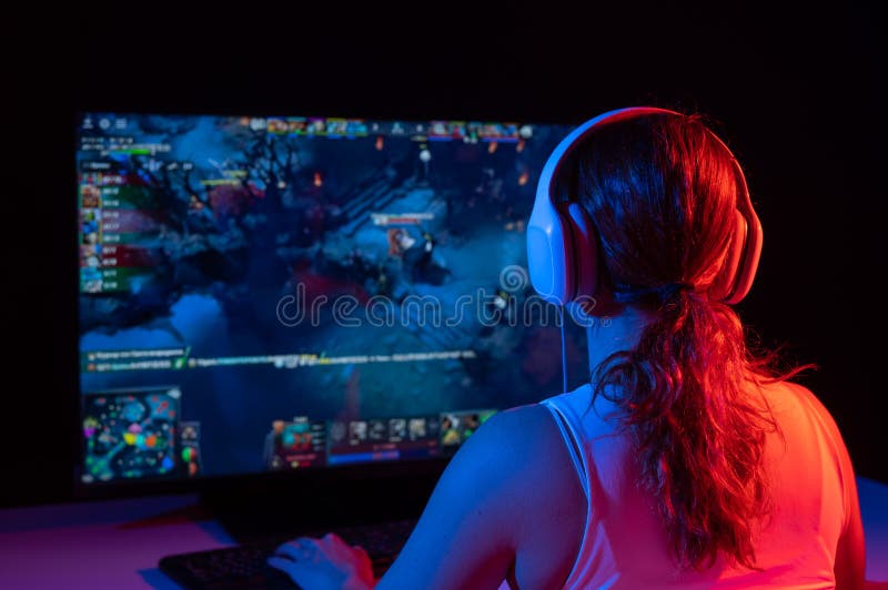 Rear View of a Caucasian Woman Playing a Computer Game in Neon Light in ...